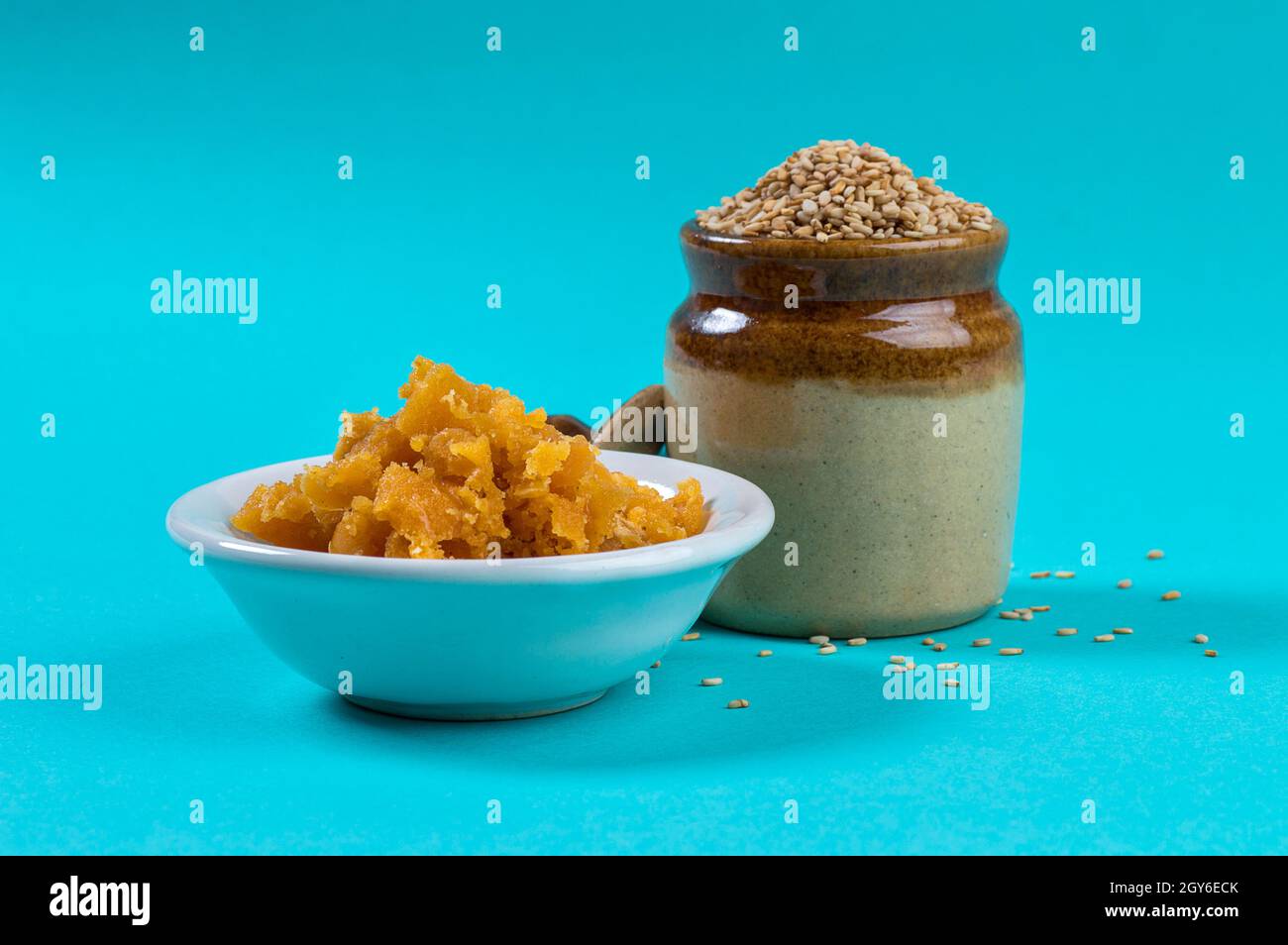 Sesame Seeds in clay pot with Jaggery in bowl on blue background Stock ...