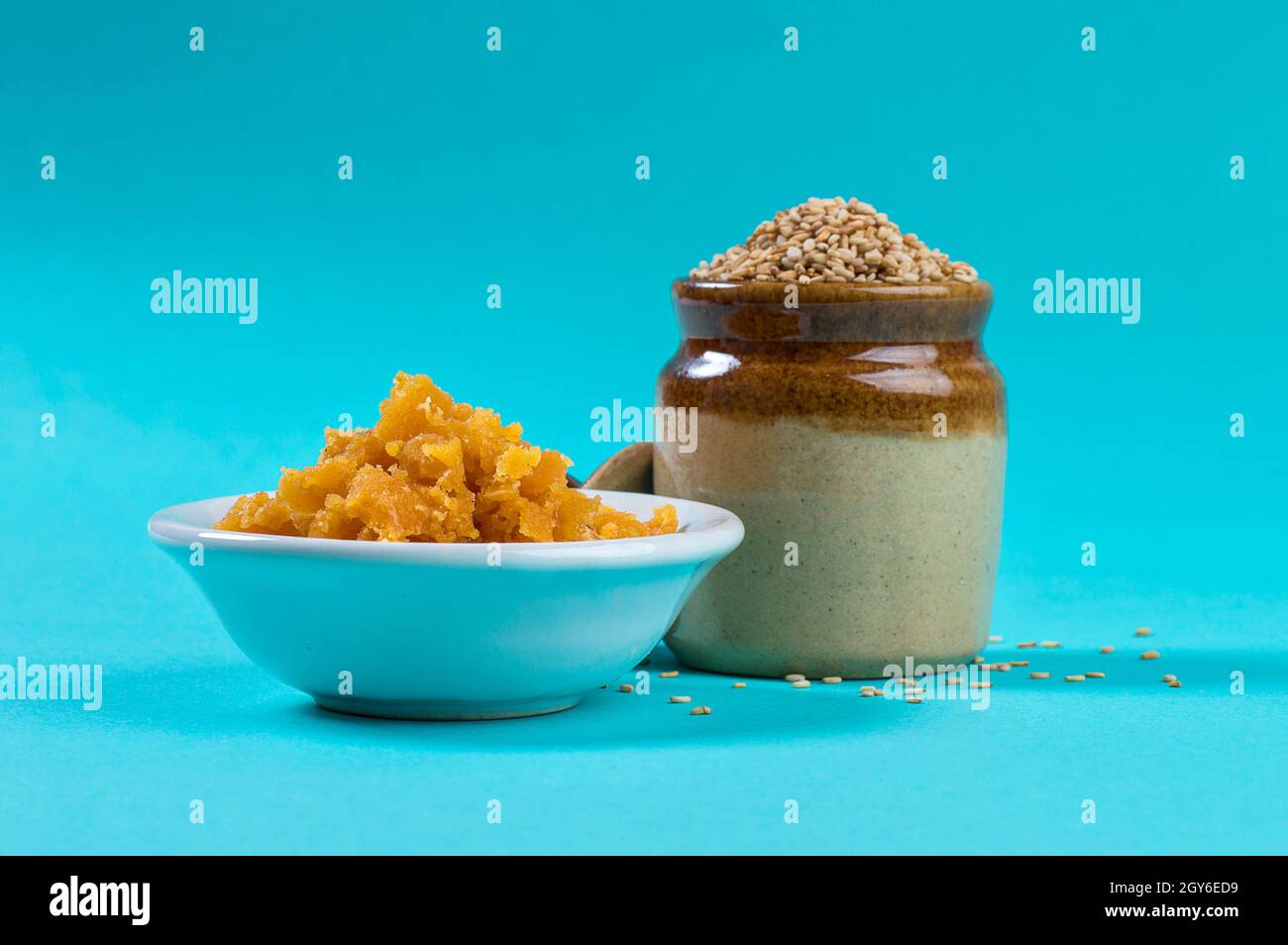 Sesame Seeds in clay pot with Jaggery in bowl on blue background Stock ...