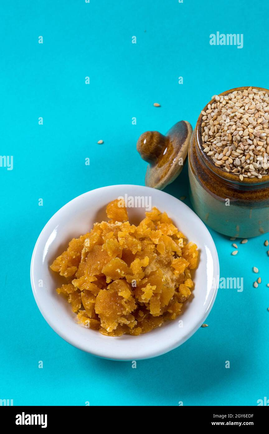Sesame Seeds in clay pot with Jaggery in bowl on blue background Stock ...