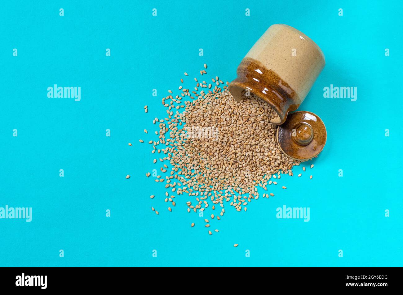 Sesame Seeds in pot on blue background Stock Photo - Alamy
