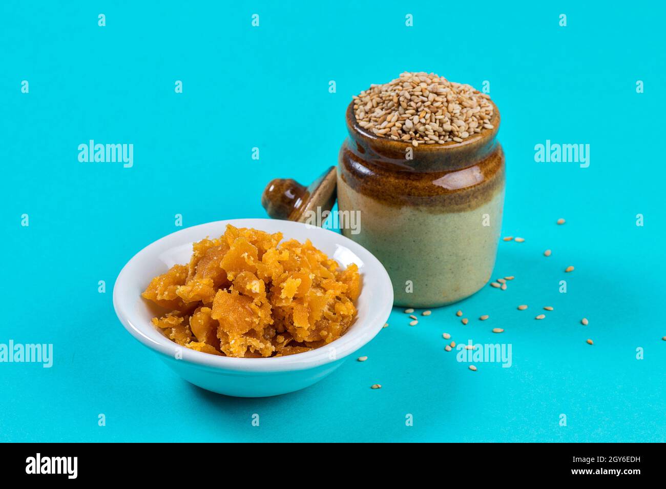 Sesame Seeds in clay pot with Jaggery in bowl on blue background Stock ...