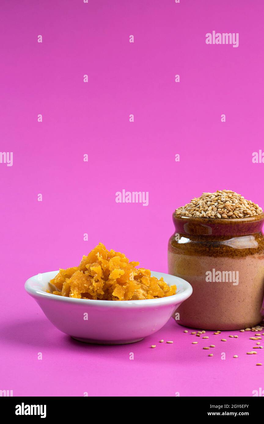 Sesame Seeds in clay pot with Jaggery in bowl on pink background Stock ...