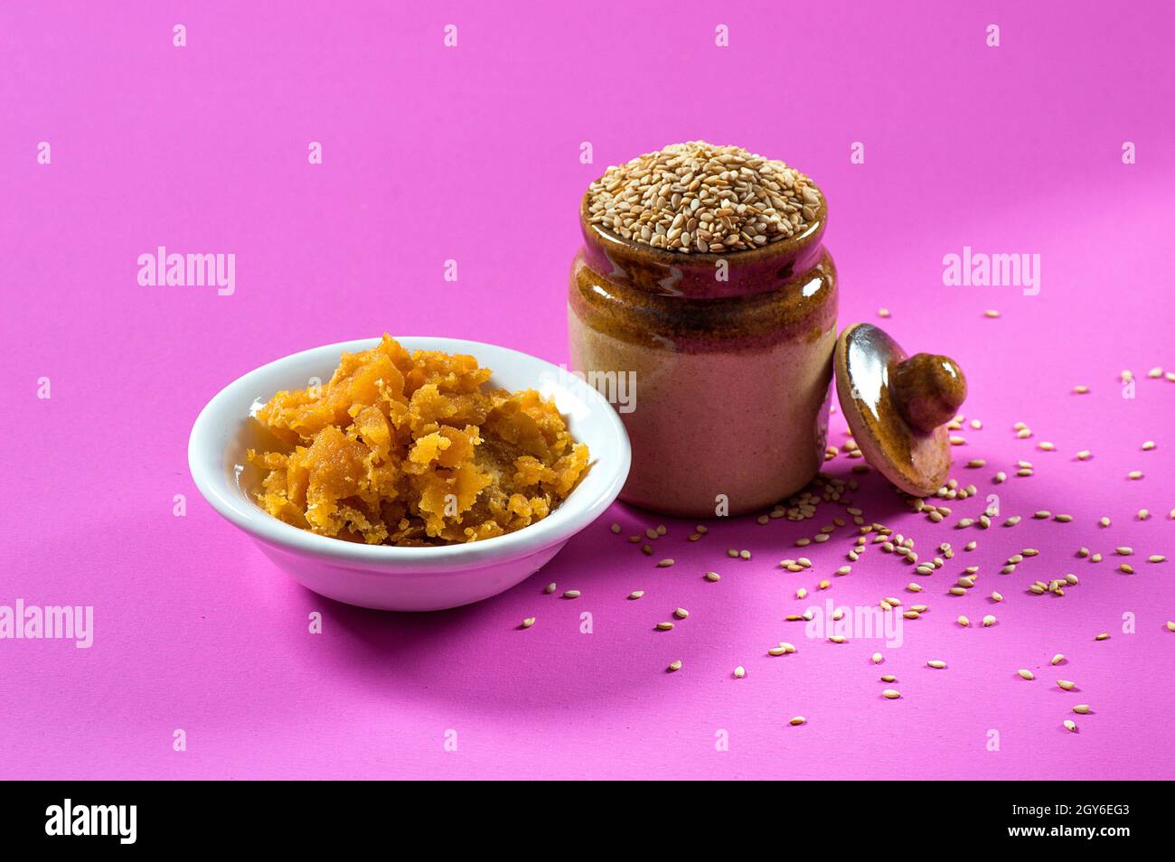 Sesame Seeds in clay pot with Jaggery in bowl on pink background Stock ...