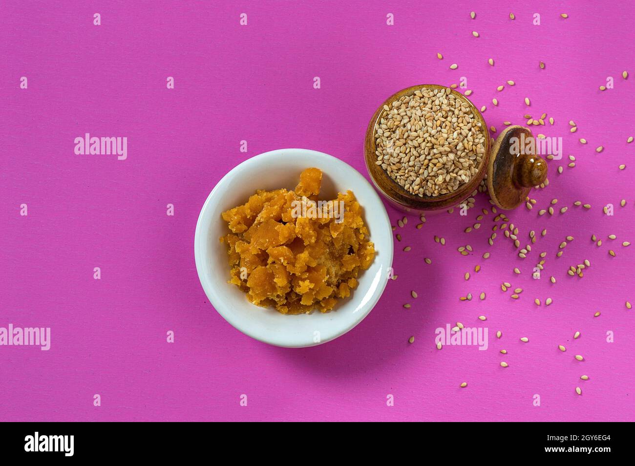 Sesame Seeds in clay pot with Jaggery in bowl on pink background Stock ...