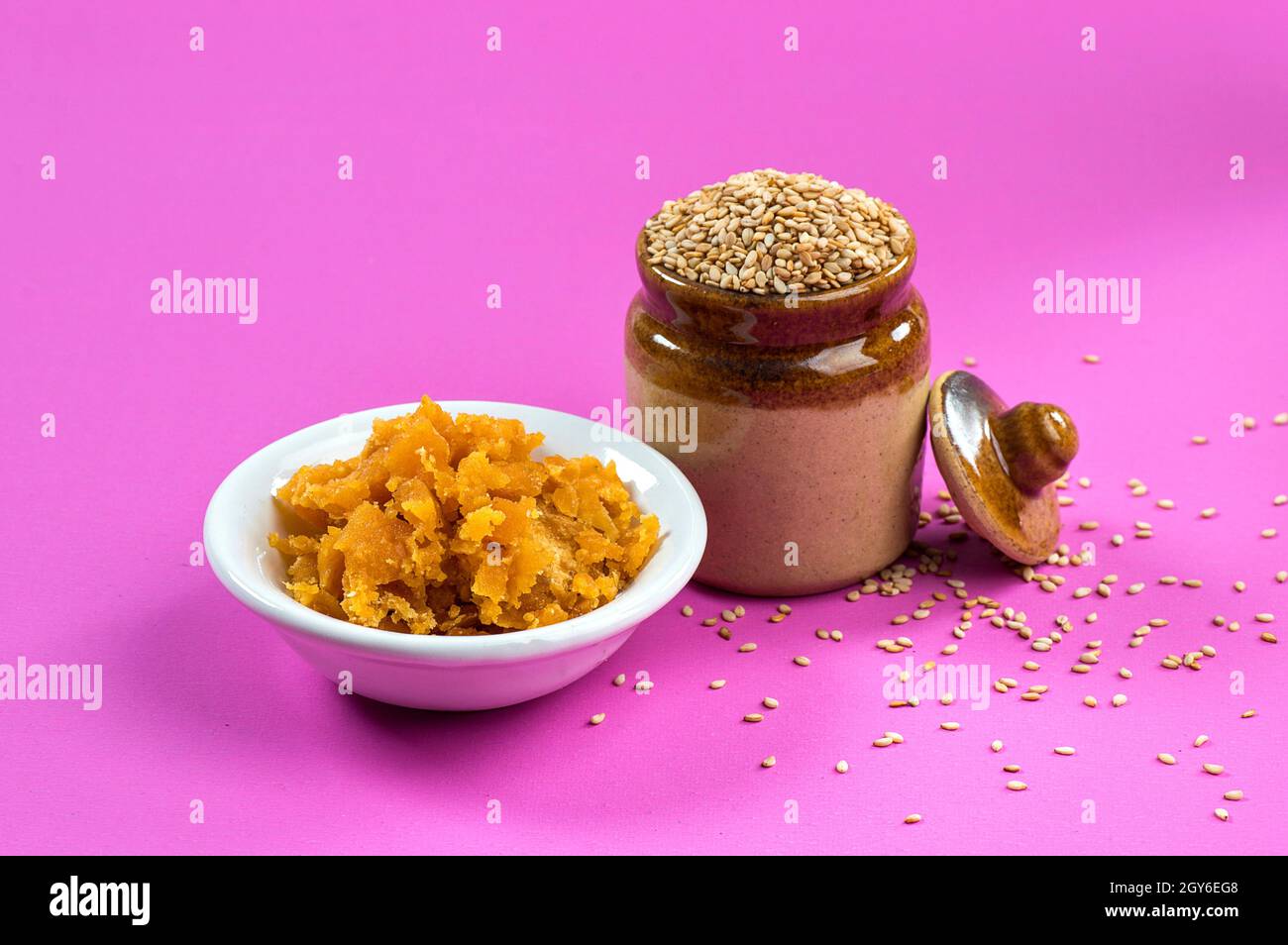 Sesame Seeds in clay pot with Jaggery in bowl on pink background Stock ...