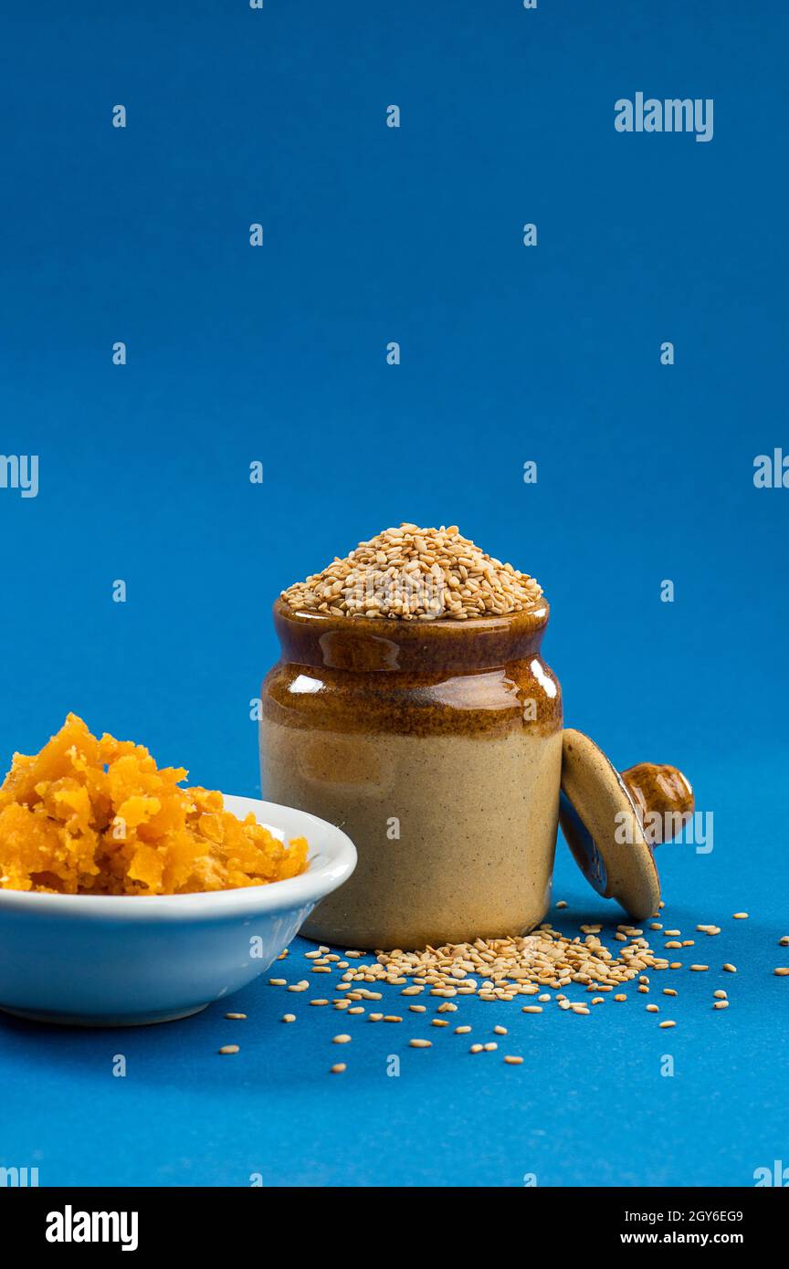 Sesame Seeds in clay pot with Jaggery in bowl on blue background Stock ...