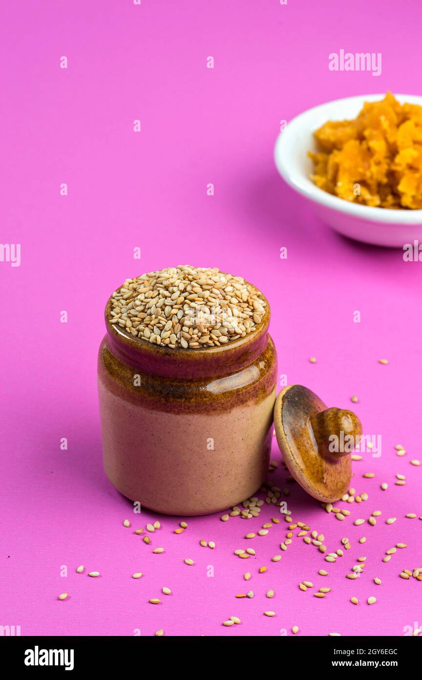 Sesame Seeds in clay pot with Jaggery in bowl on pink background Stock ...