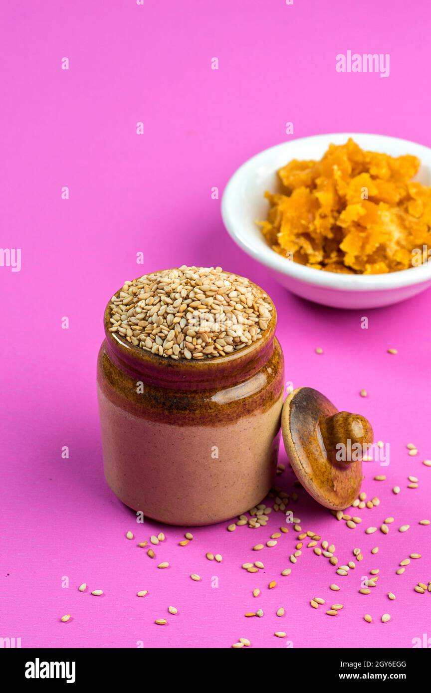 Sesame Seeds in clay pot with Jaggery in bowl on pink background Stock ...