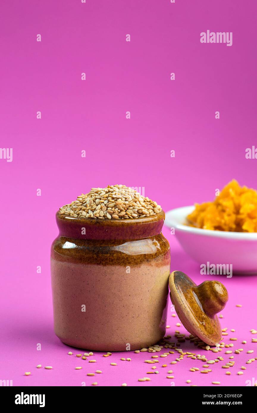 Sesame Seeds in clay pot with Jaggery in bowl on pink background Stock ...