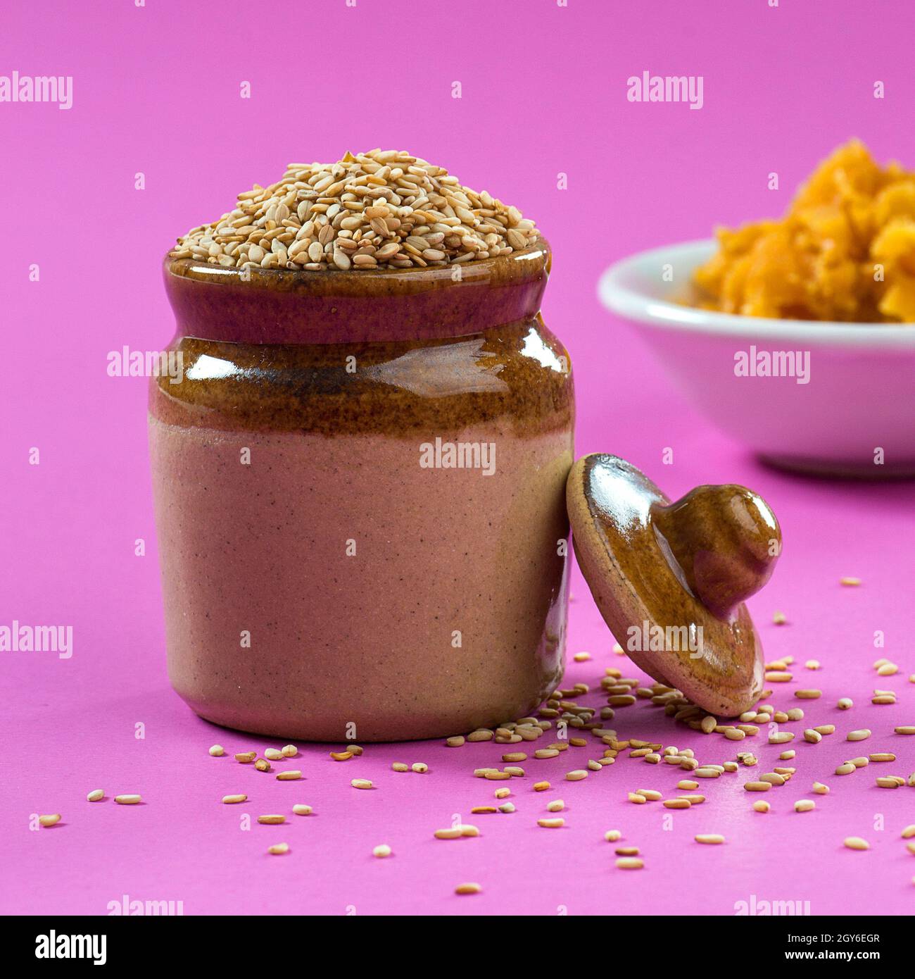 Sesame Seeds in clay pot with Jaggery in bowl on pink background Stock ...