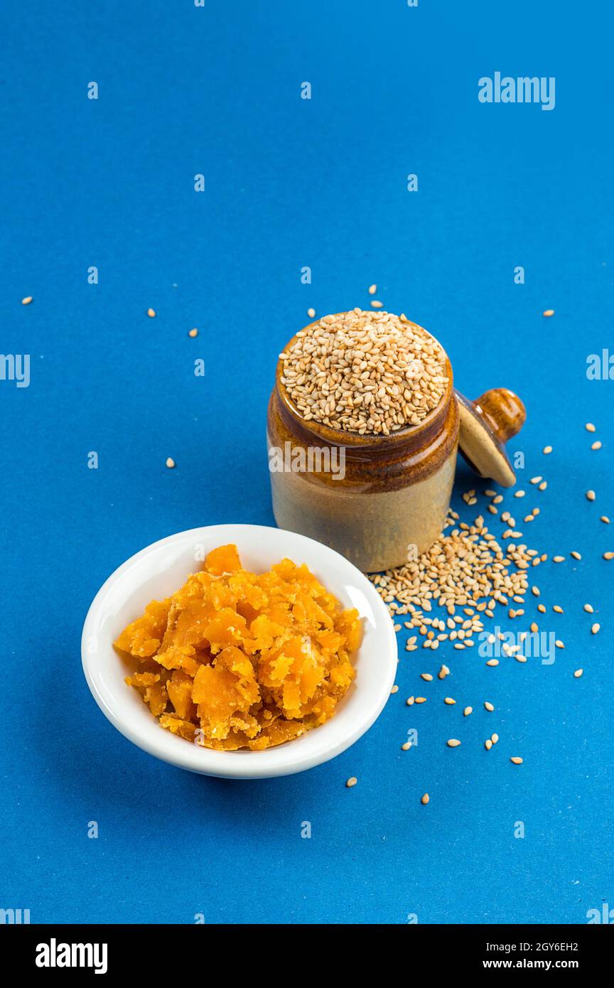Sesame Seeds in clay pot with Jaggery in bowl on blue background Stock ...