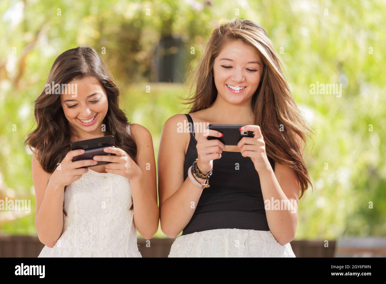 Two Expressive Mixed Race Girlfriends Using Their Smart Cell Phones