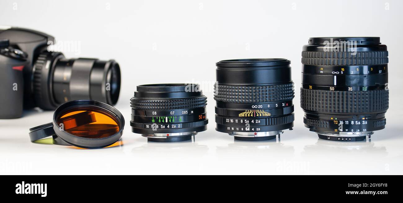 Camera, color filters and photo lens on white background with ...