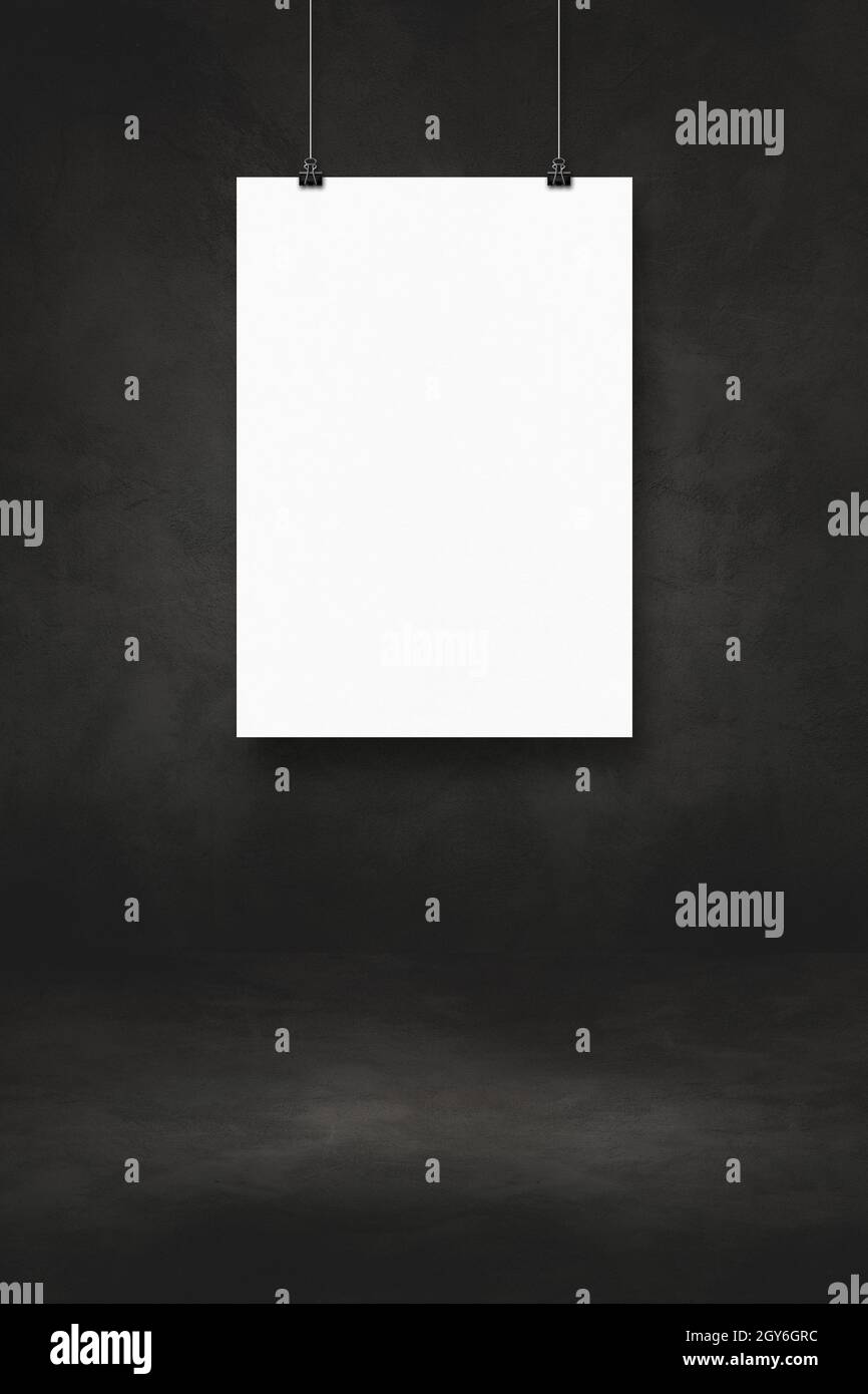 White poster hanging on a black wall with clips. Blank mockup template ...