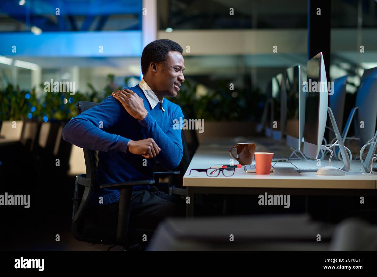 Drowsy young manager works in night office. Sleepy male businessman ...