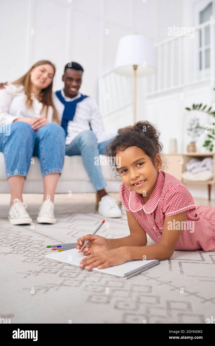 Happy family resting in living room. Mother, father and their daughter ...
