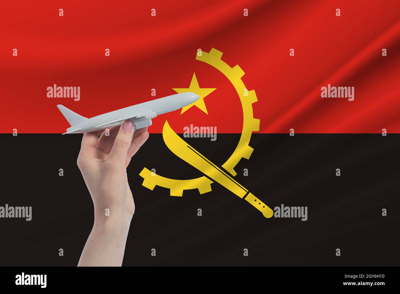 Airplane in hand with national flag of Angola. Travel to Angola Stock ...