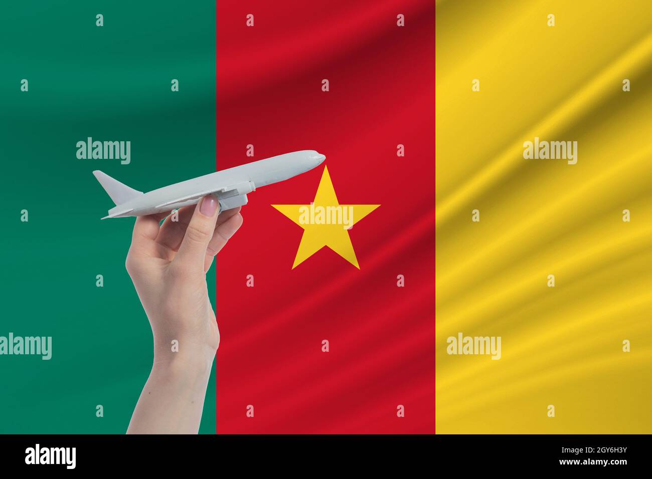 Airplane in hand with national flag of Cameroon Travel to Cameroon ...