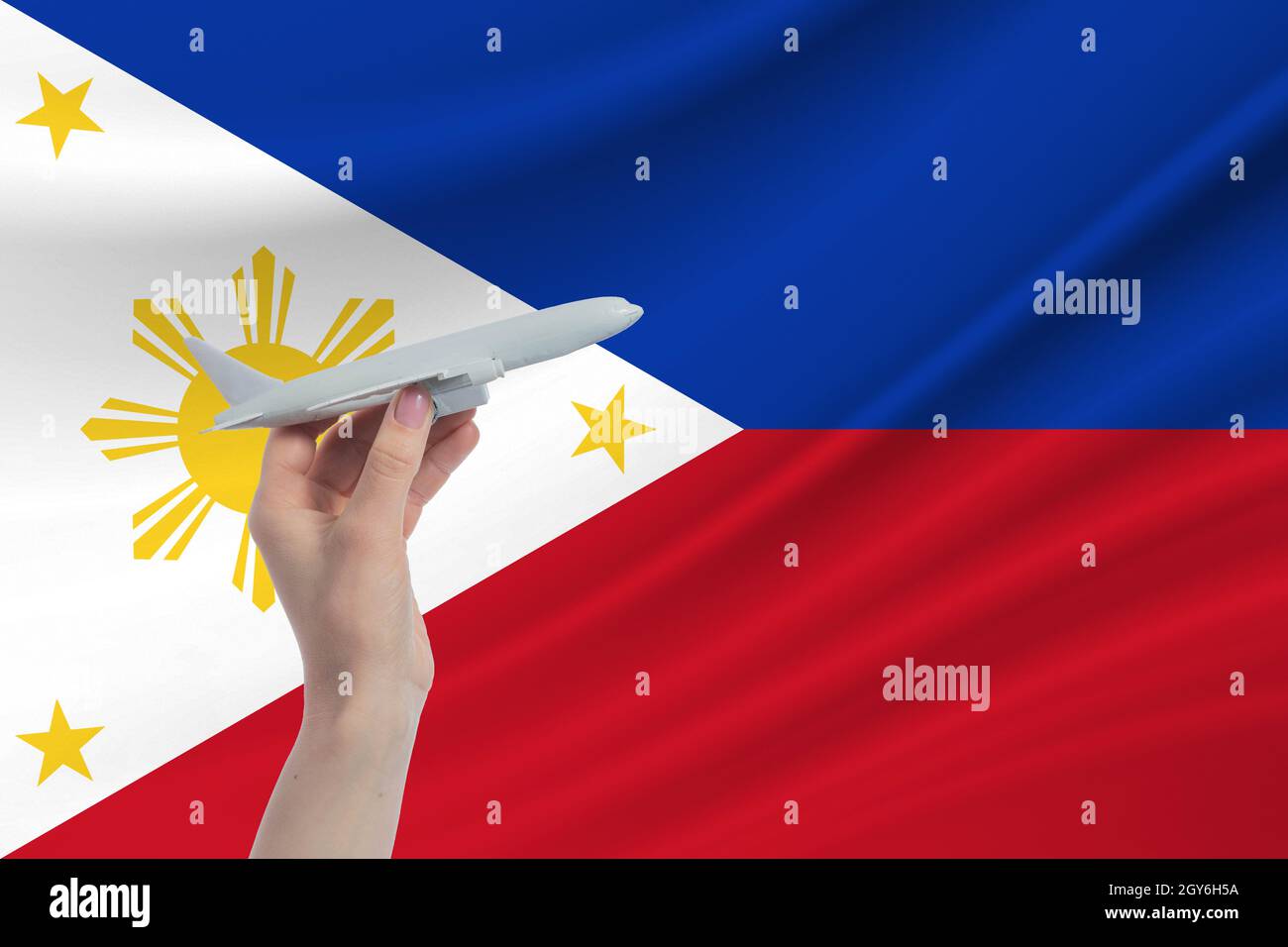 Airplane in hand with national flag of Philippines. Travel to ...