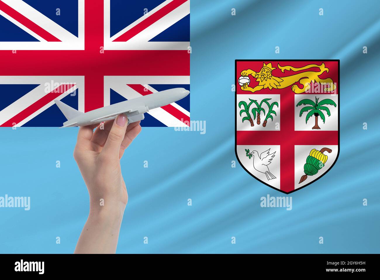 Airplane in hand with national flag of Fiji. Travel to Fiji Stock Photo ...