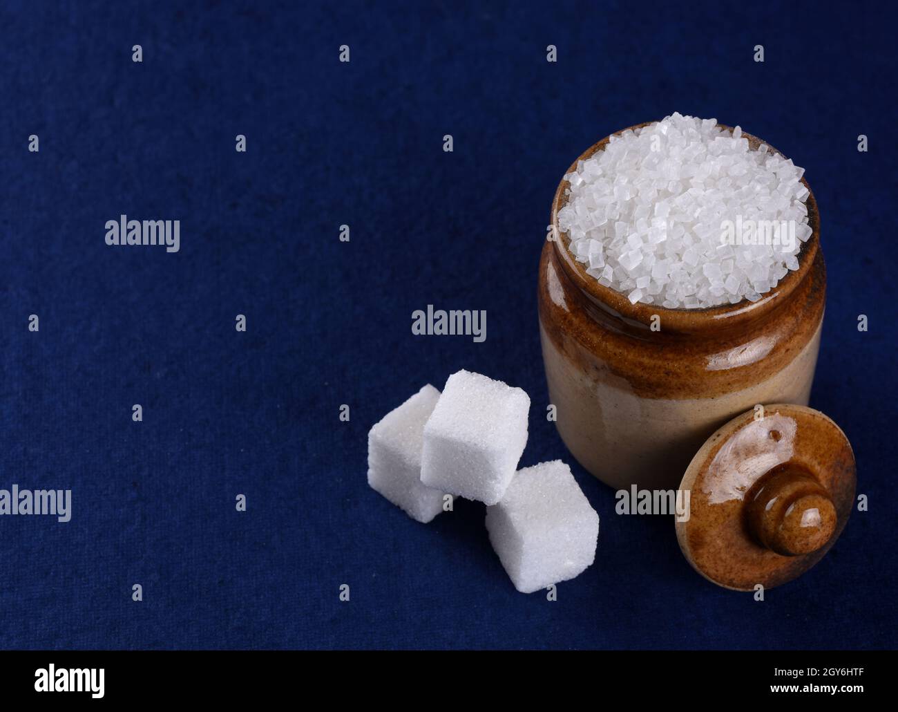 Sugar. white granulated sugar and refined sugar on a blue background ...