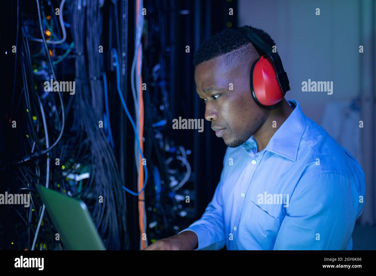 African american male computer technician wearing headphones using ...