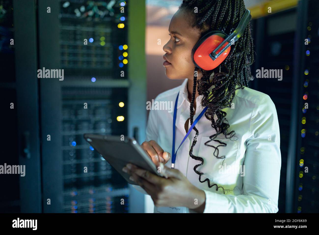 African american female computer technician wearing headphones using ...