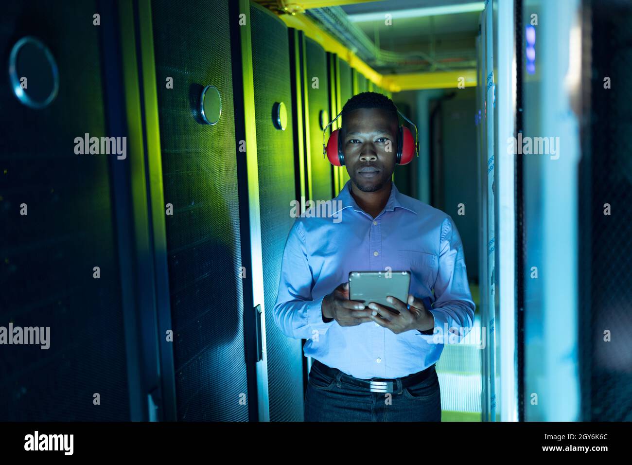 African american male computer technician wearing headphones using ...