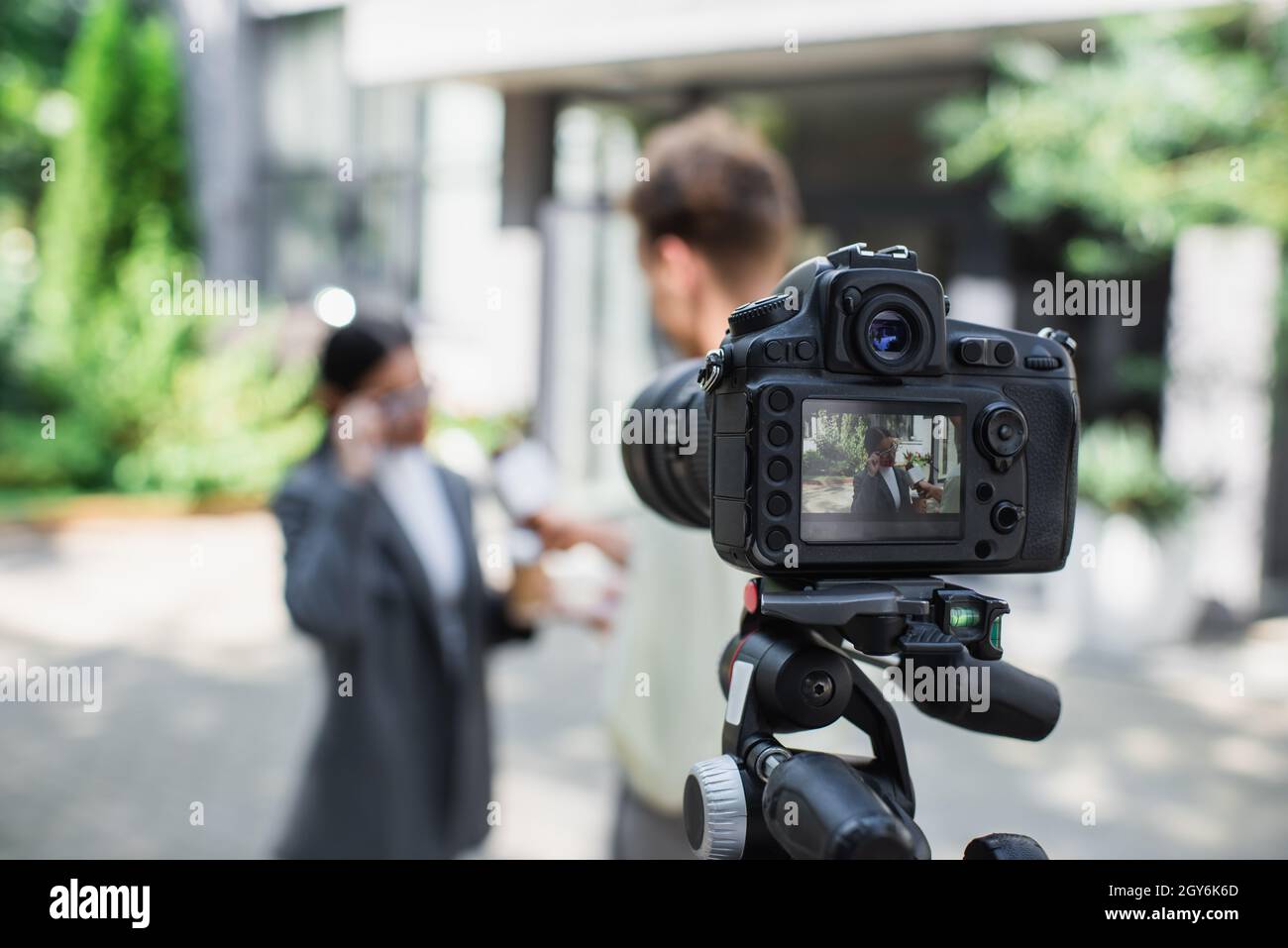 digital camera with reporter holding microphone while taking interview ...