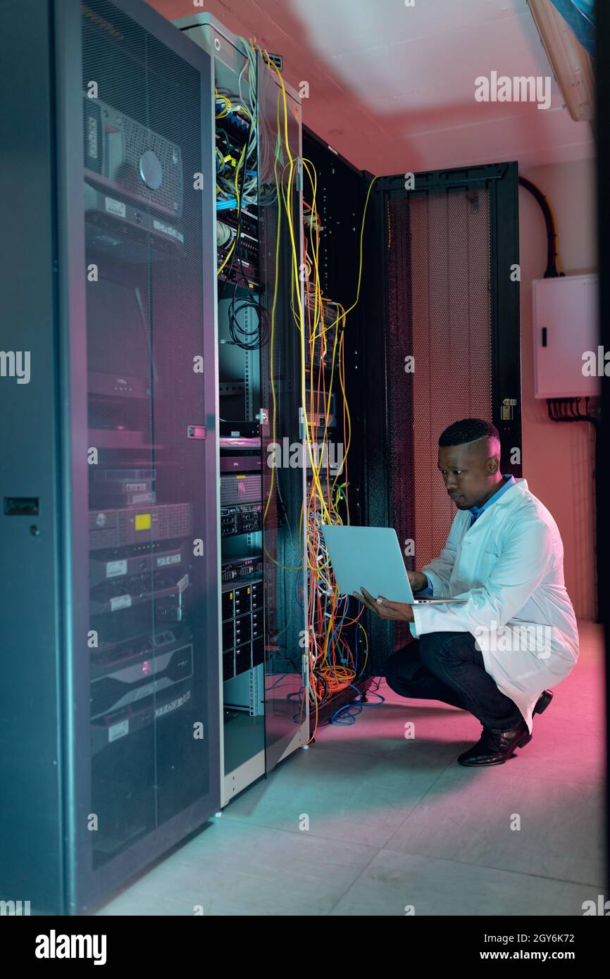 African american male computer technician using laptop working in ...