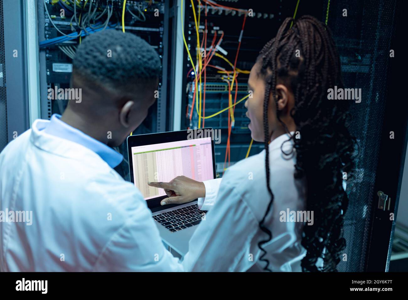 African american computer technicians using laptop working in server ...