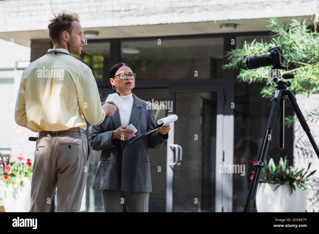 reporter taking interview with asian businesswoman in suit holding ...