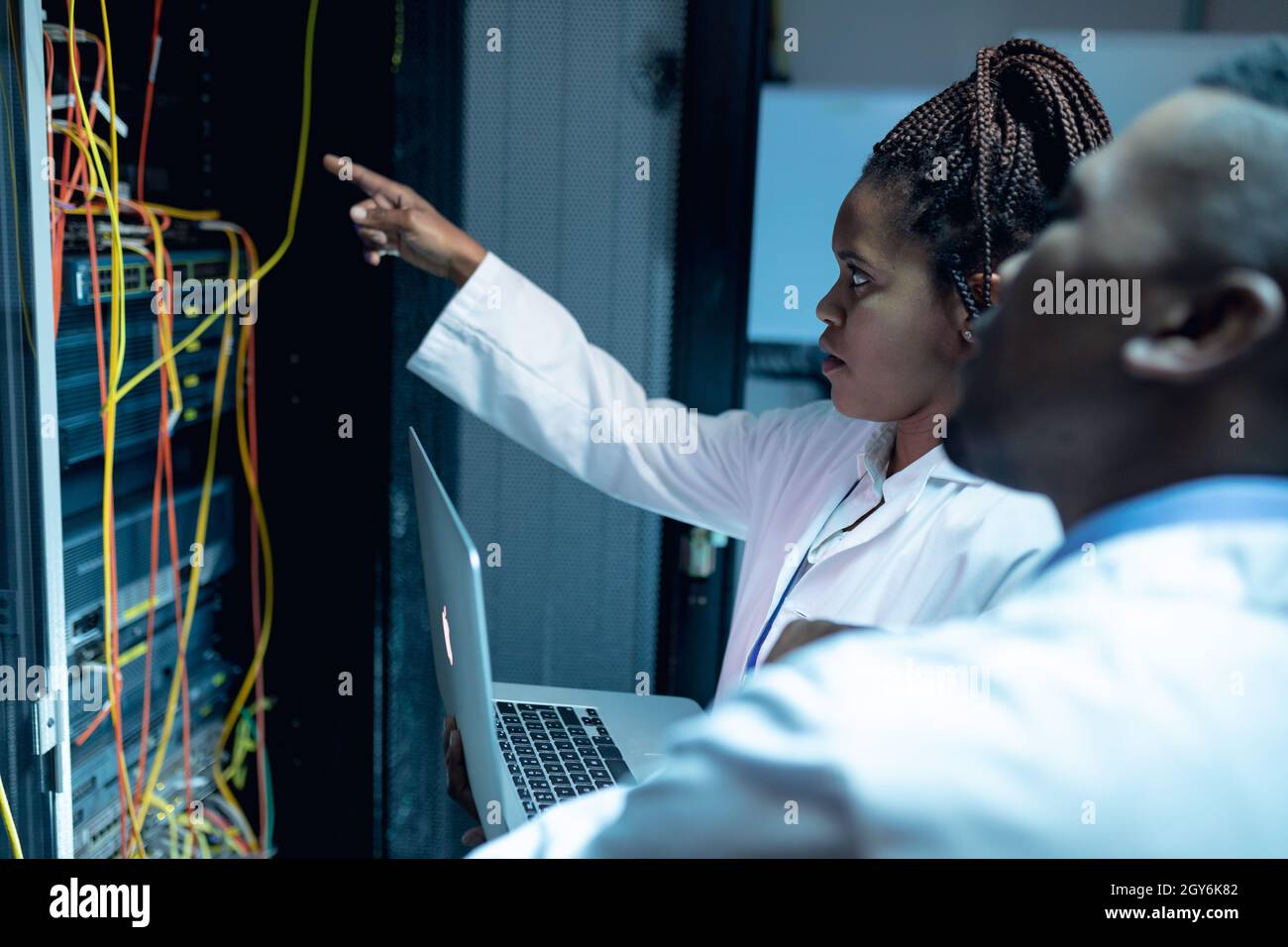African american computer technicians using laptop working in server ...