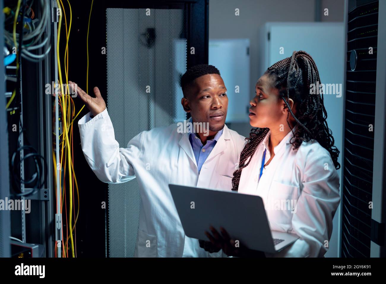 African american computer technicians using laptop working in server ...