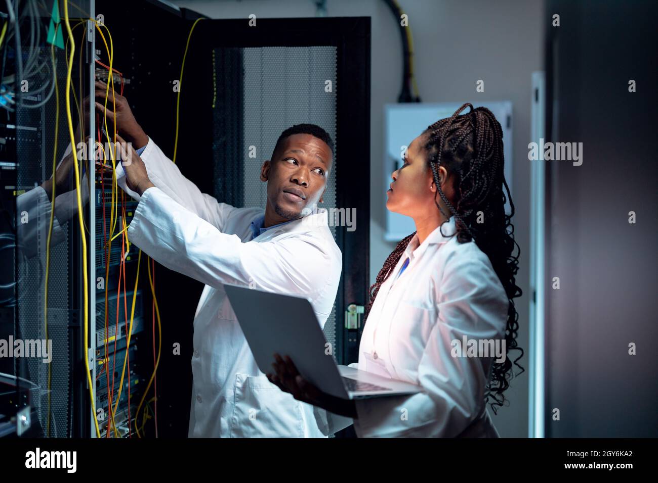 African american computer technicians using laptop working in server ...