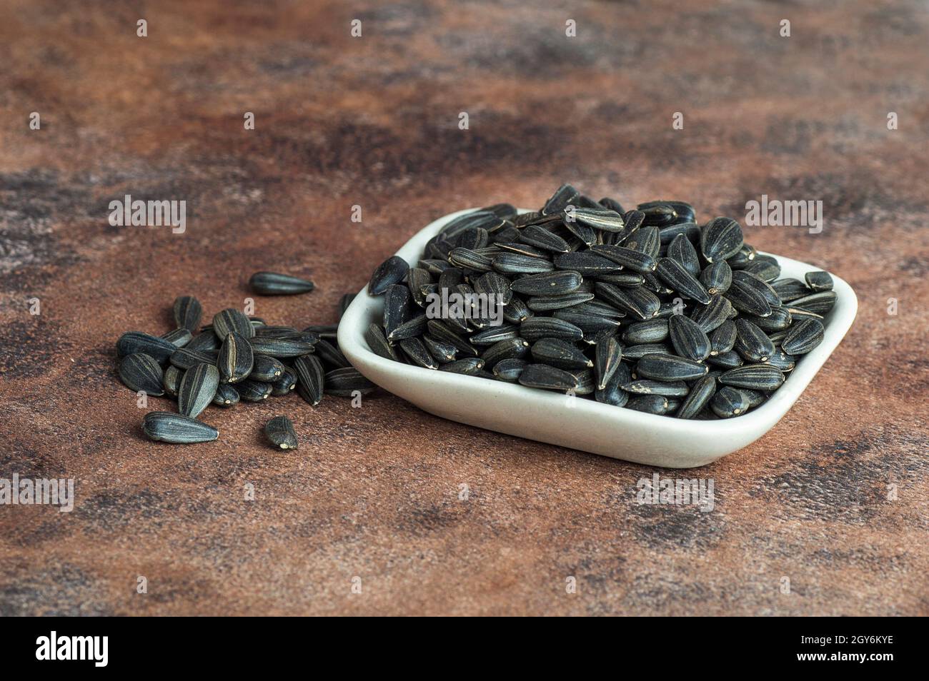 Sunflower Seeds (Helianthus annuus) in white on stone background Stock ...