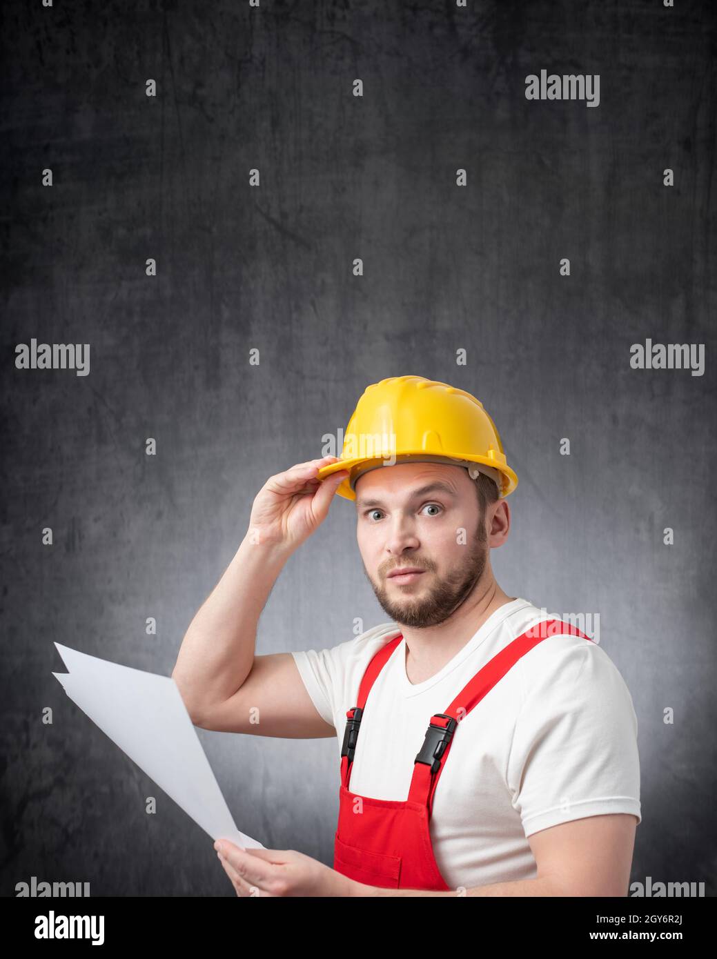 Confused construction worker trying to understand documents Stock Photo ...