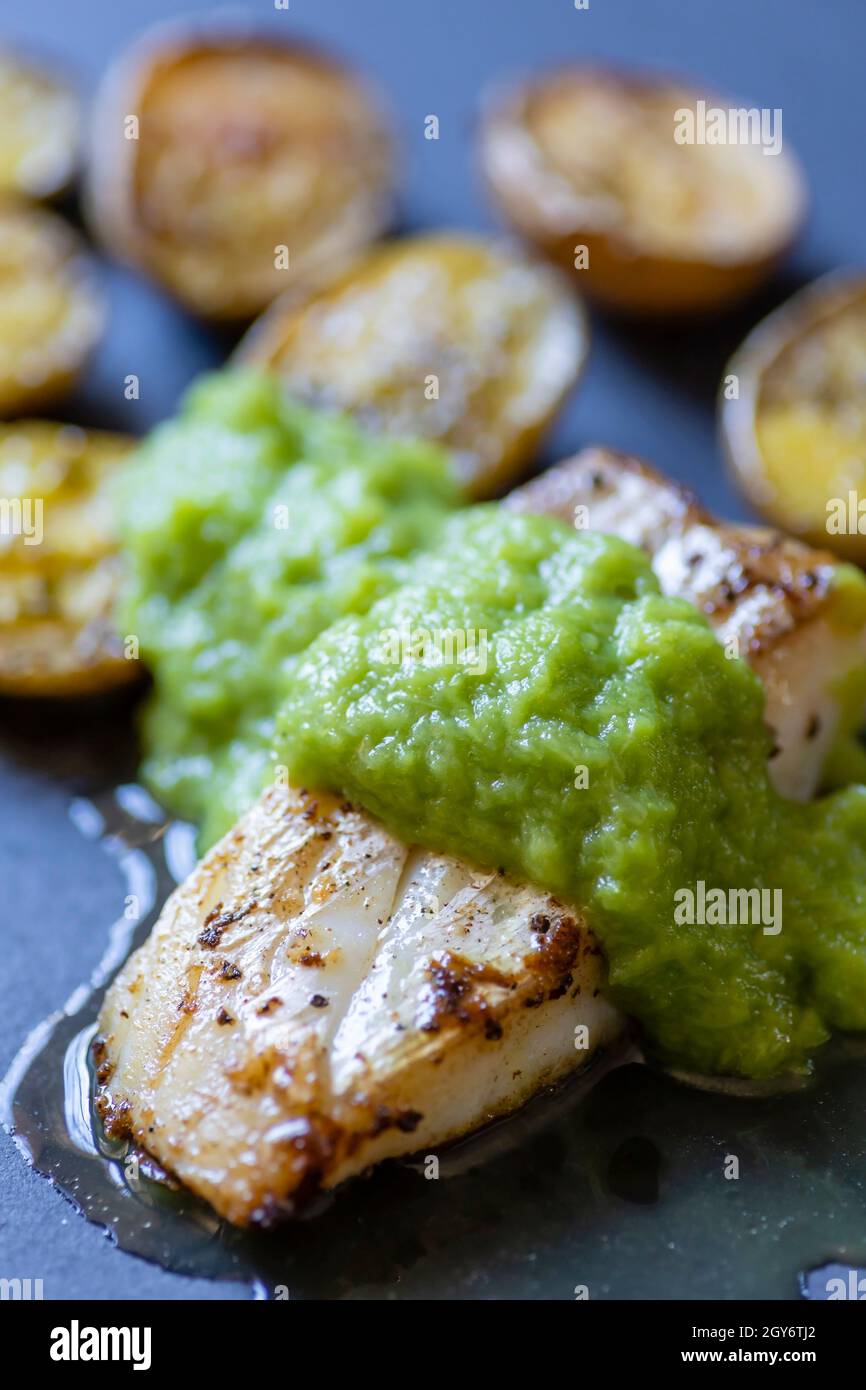 frilled cod fish with green asparagus sauce and fried potatoes Stock ...