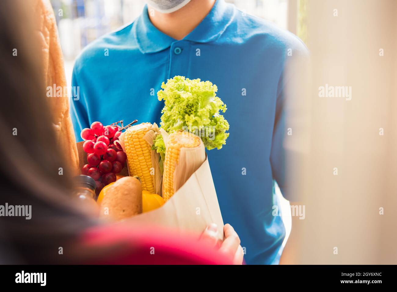 Asian young delivery man in uniform wear protective face mask he making ...