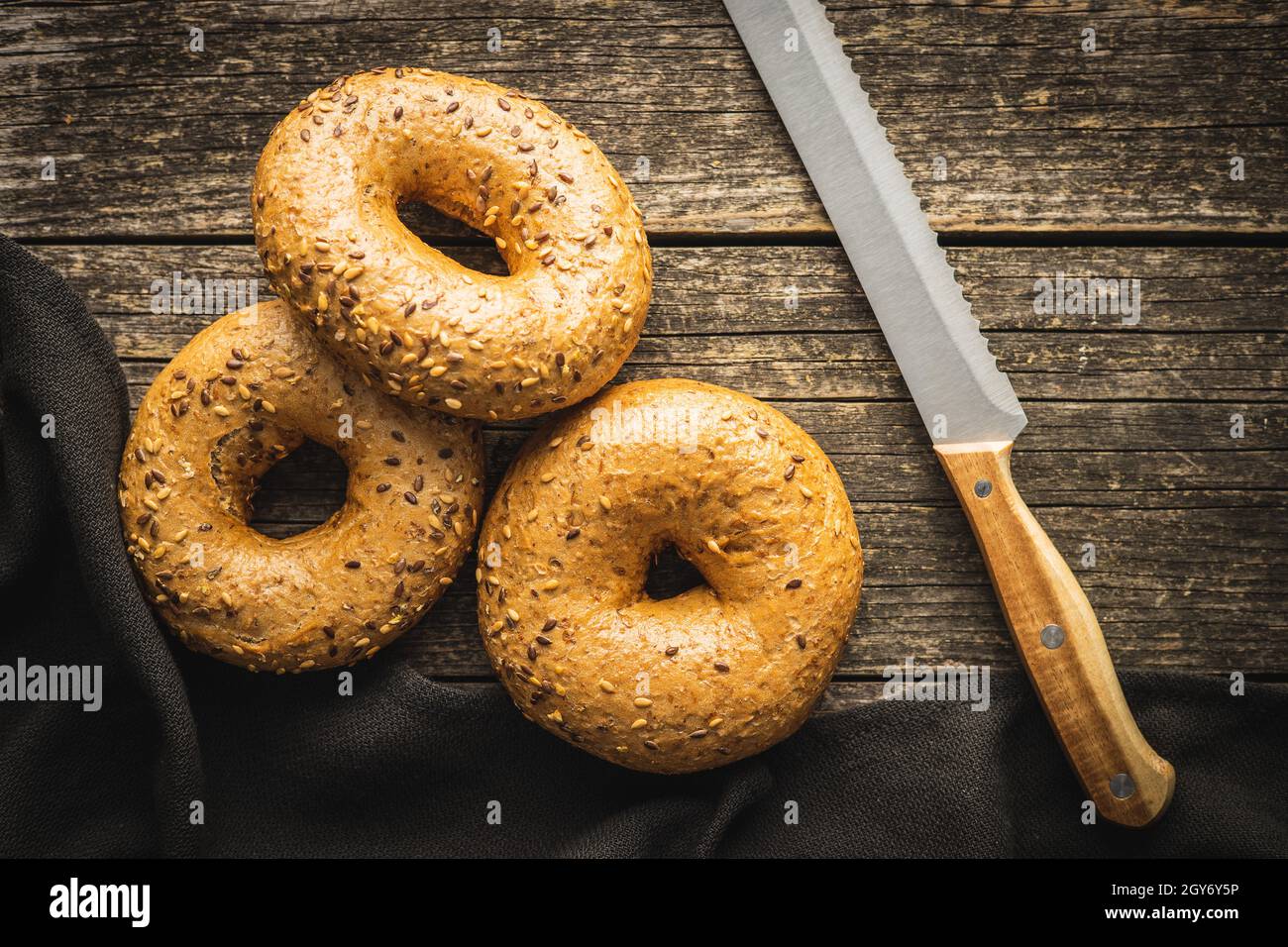 Whole grain baked bagel on wooden table. Top view Stock Photo - Alamy