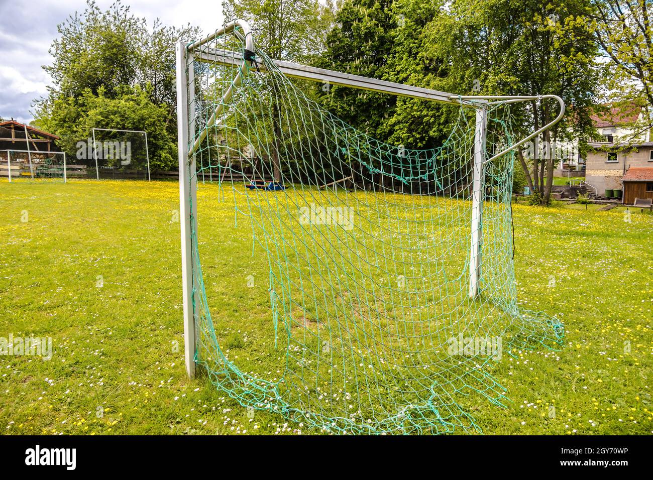 Small empty soccer field with goal and bbroken net on a beautiful ...