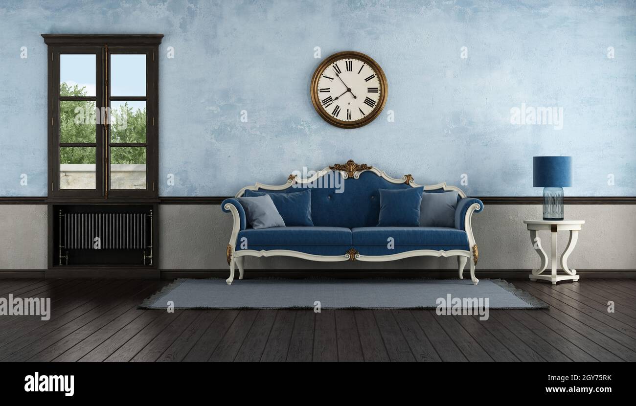Blue classic sofa in a old room with old radiator under wooden windows ...
