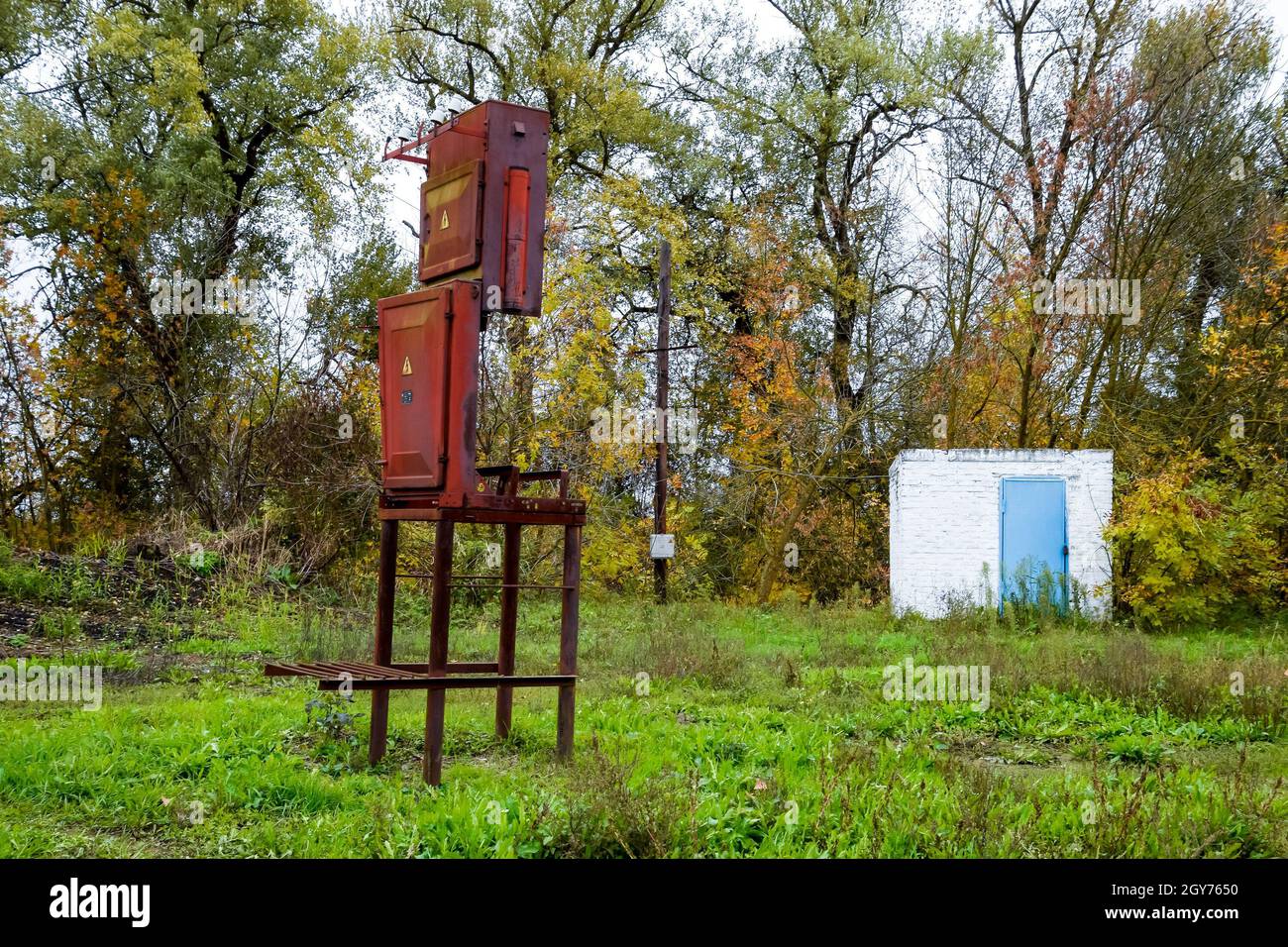 Old rusty electric transformer in the park. Electric transformer box ...