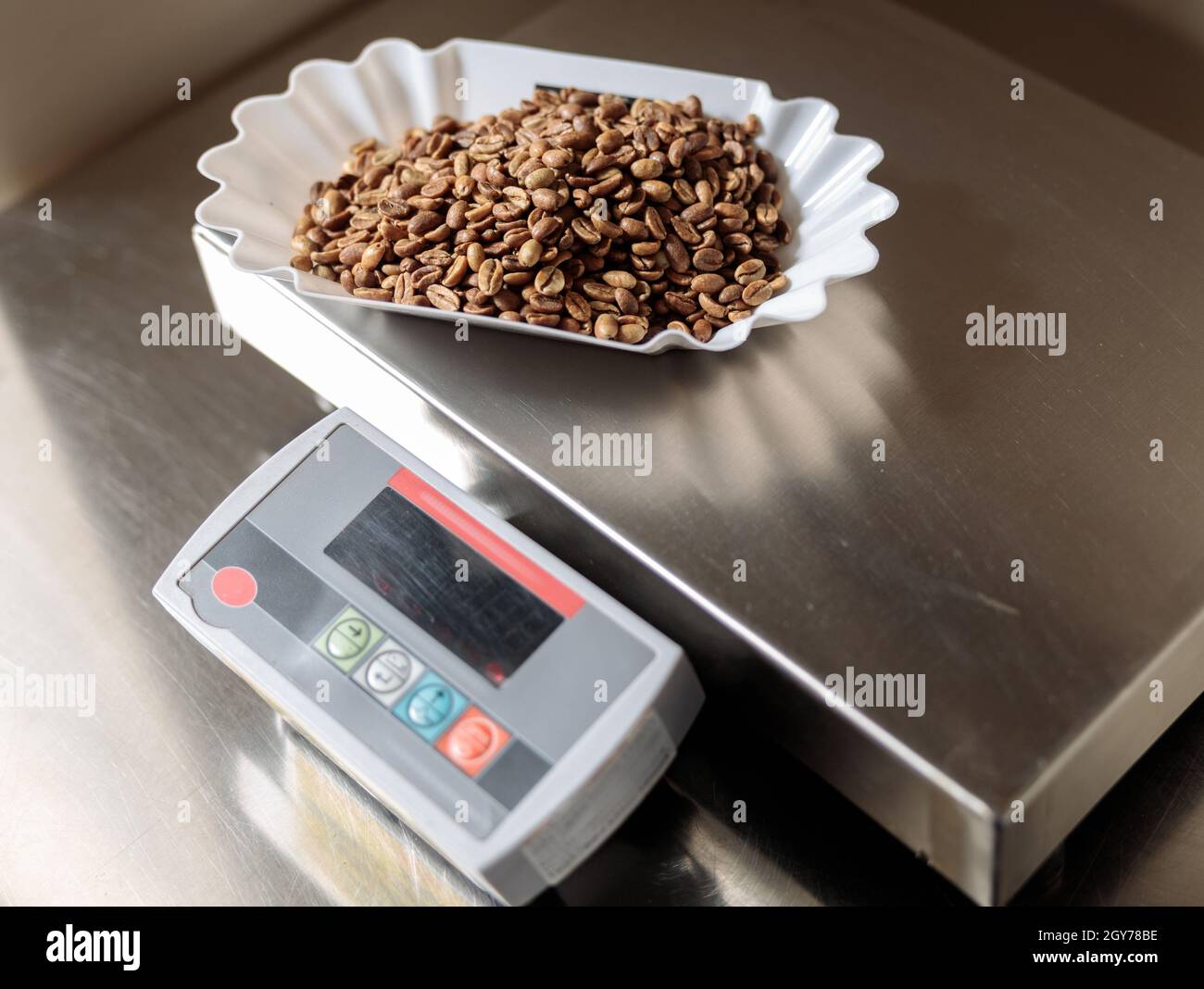 Electronic scales with white bowl of coffee beans Stock Photo - Alamy