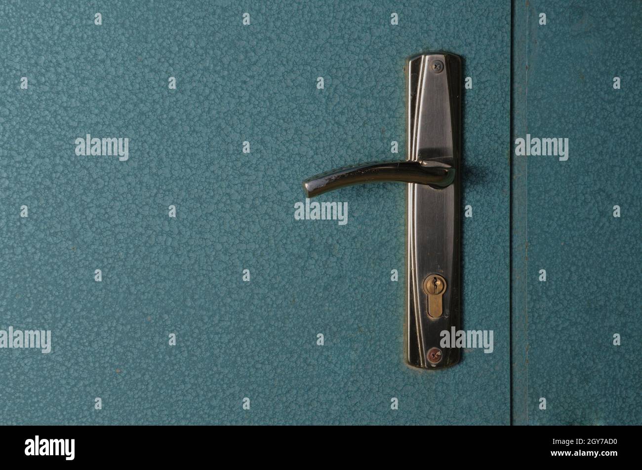 Chrome door lock on blue iron door Stock Photo - Alamy
