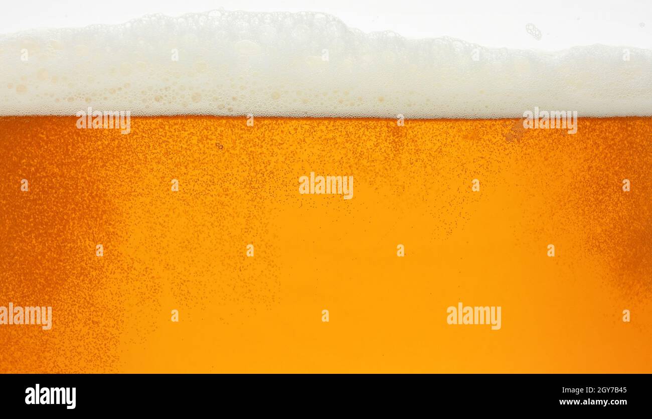 Close up background texture of lager beer with bubbles and froth ...
