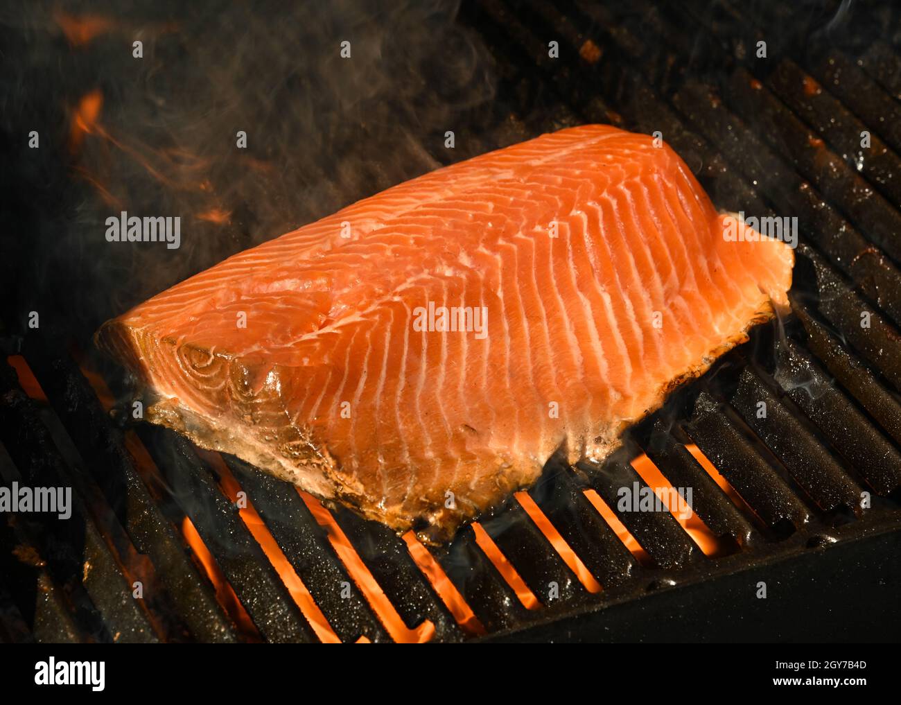 Close up searing and smoking salmon fish fillet on open fire outdoor ...