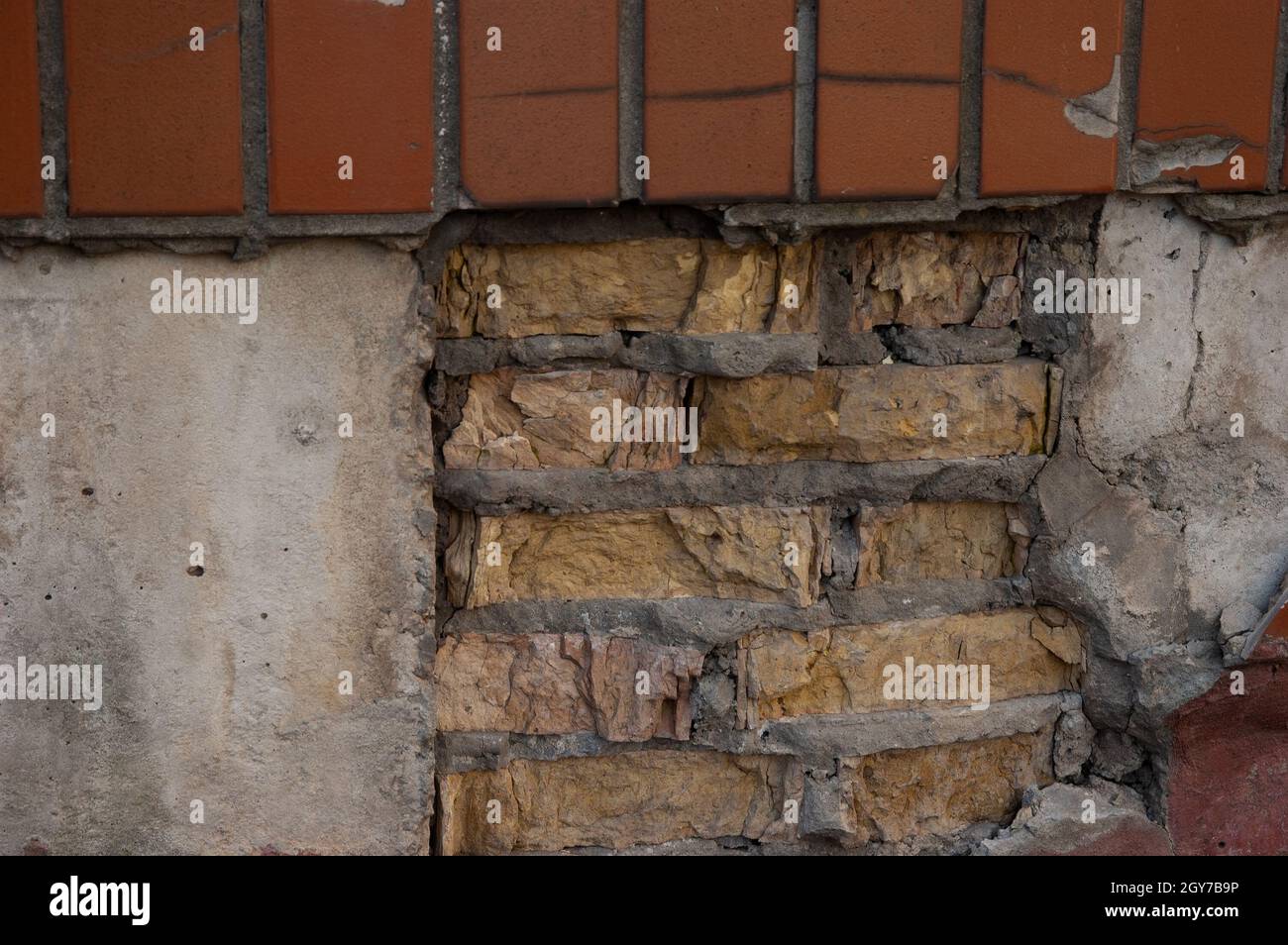 Rough rimmed wall with concrete, bricks and brown tiles Stock Photo - Alamy