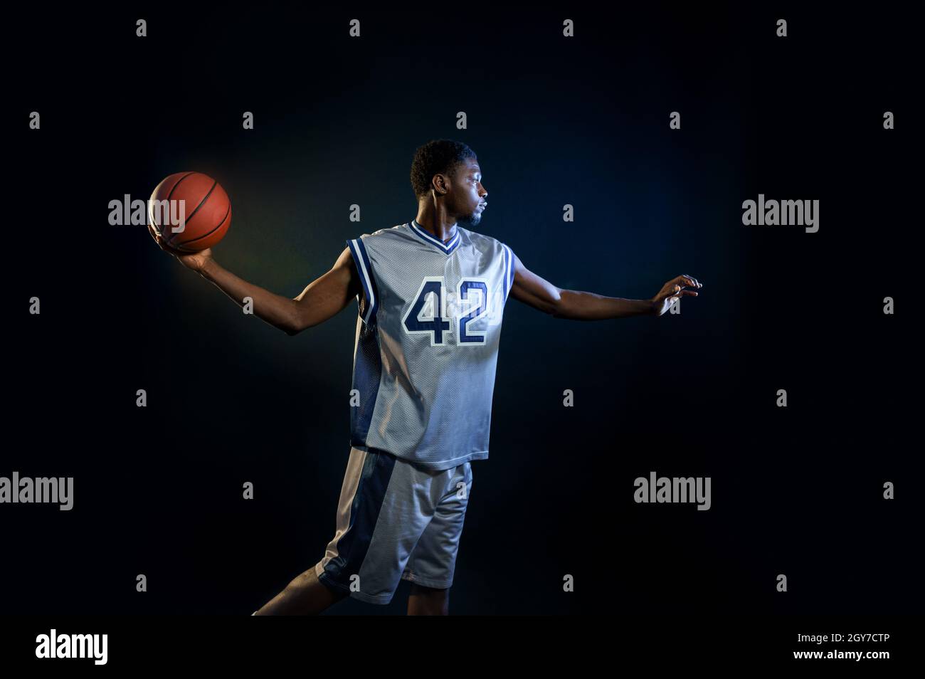 Basketball player with ball, practicing in action in studio, black ...