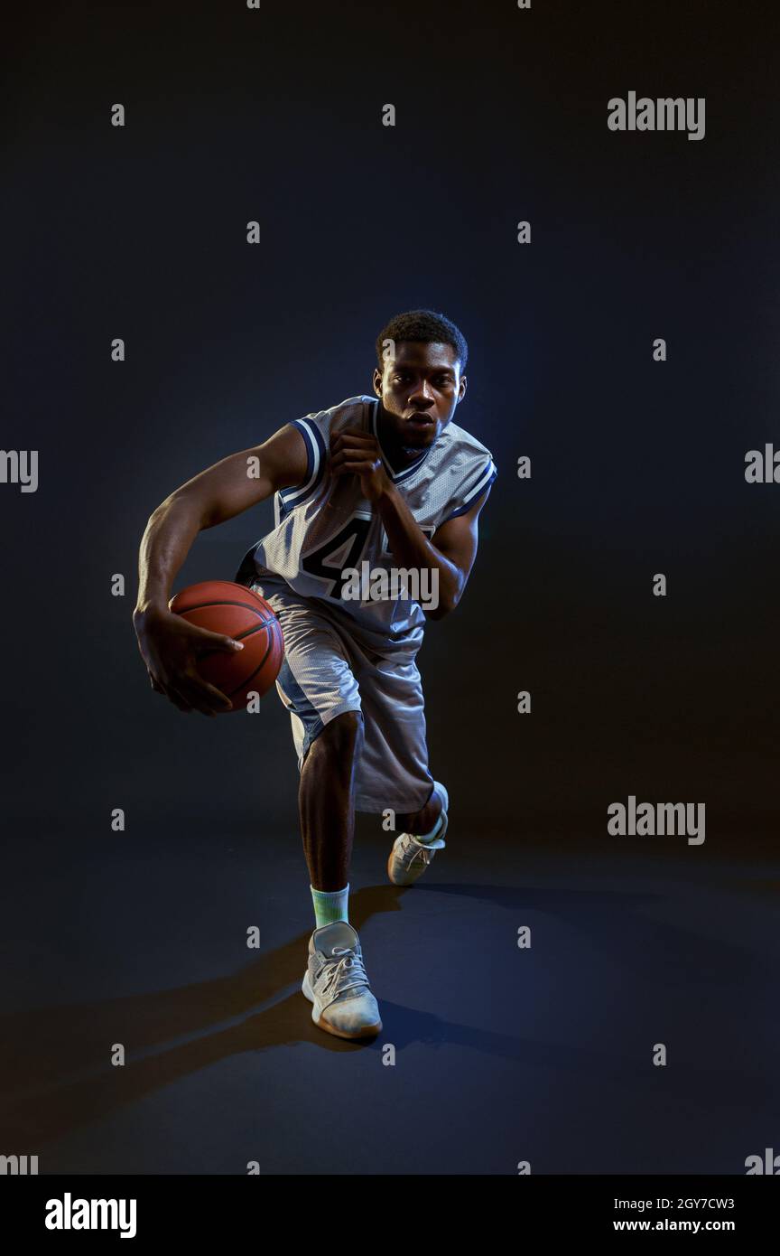 Basketball player with ball, practicing in action in studio, black ...